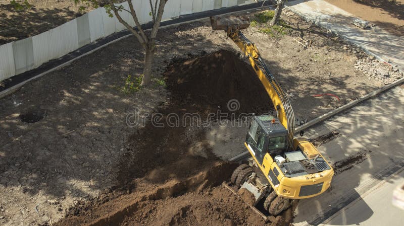 Yellow Excavator Digs a Hole at a Construction Site, Top View Stock ...
