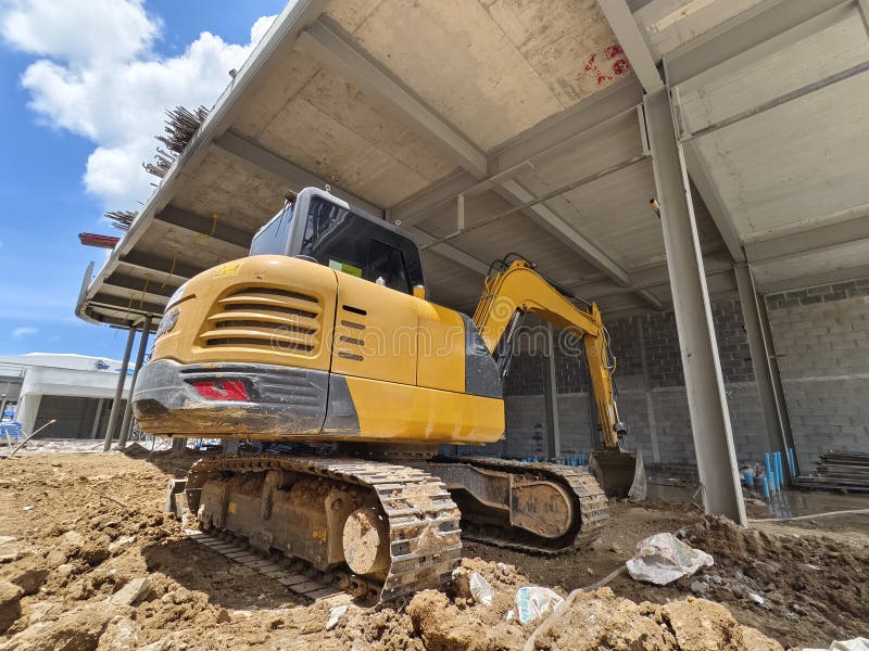 A Yellow Excavator is in Front of a Building Under Construction Stock ...