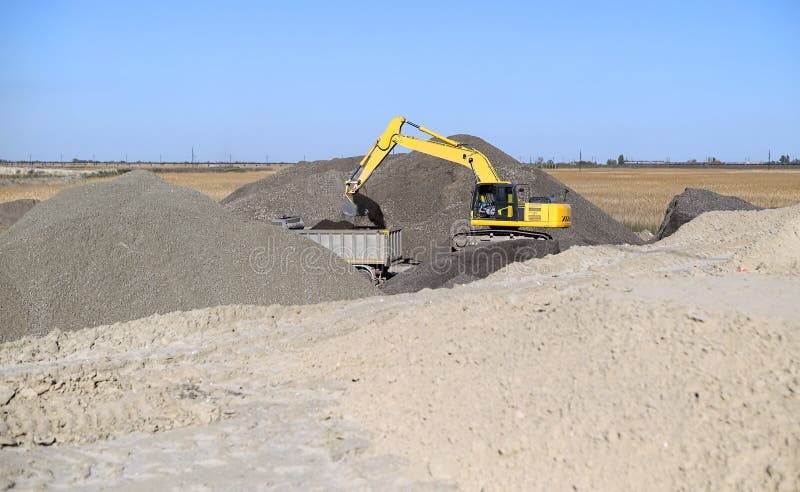 Yellow Excavator Involved in the Construction of a Highway Loading ...