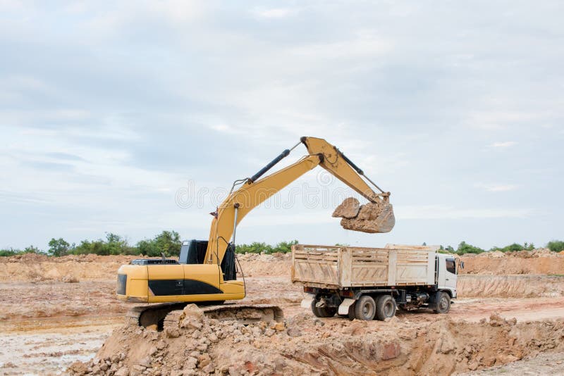 Yellow Excavator Machine Loading Soil into a Dump Truck at Construction ...