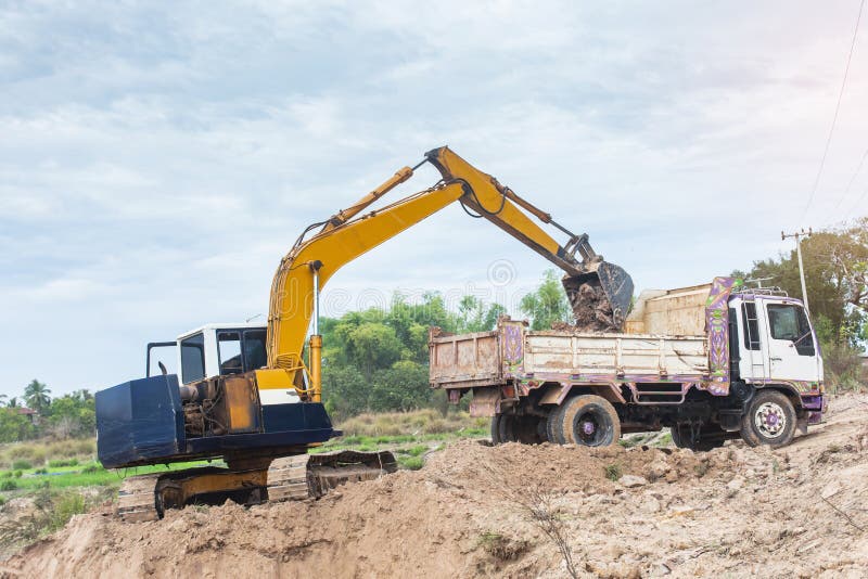 Yellow Excavator Machine Loading Soil into a Dump Truck at Construction ...