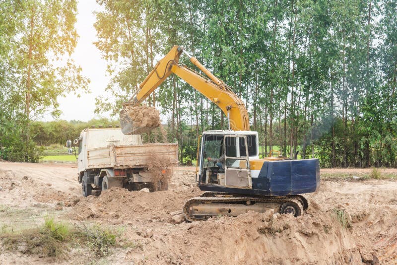 Yellow Excavator Machine Loading Soil into a Dump Truck at Construction ...