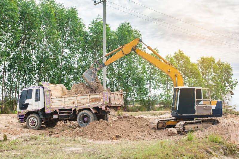 Yellow Excavator Machine Loading Soil into a Dump Truck at Construction ...
