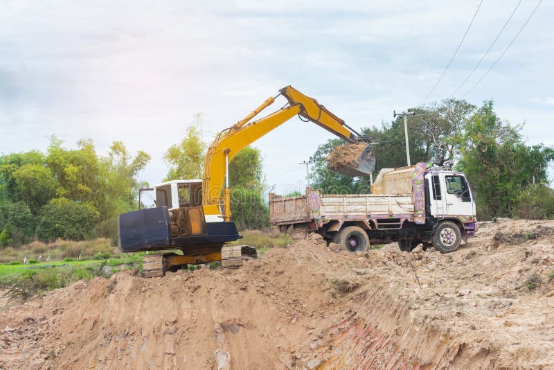 Yellow Excavator Machine Loading Soil into a Dump Truck at Construction ...