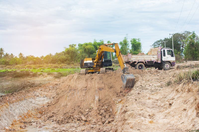 Yellow Excavator Machine Loading Soil into a Dump Truck at Construction ...