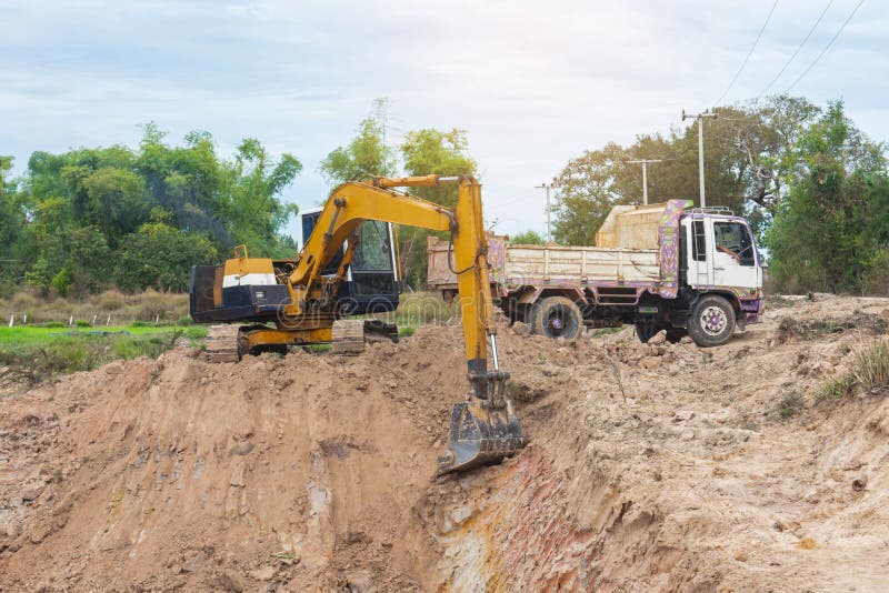 Yellow Excavator Machine Loading Soil into a Dump Truck at Construction ...