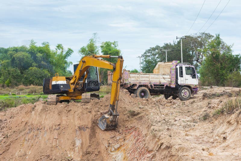 Yellow Excavator Machine Loading Soil into a Dump Truck at Construction ...