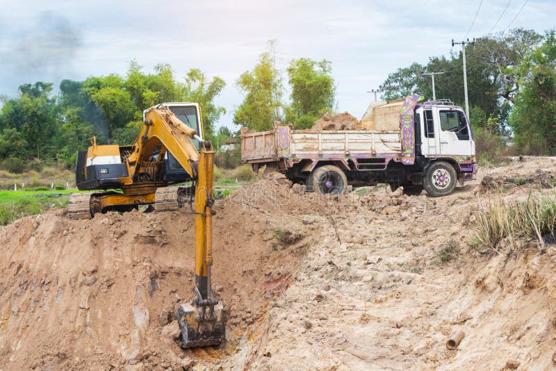 Yellow Excavator Machine Loading Soil into a Dump Truck at Construction ...