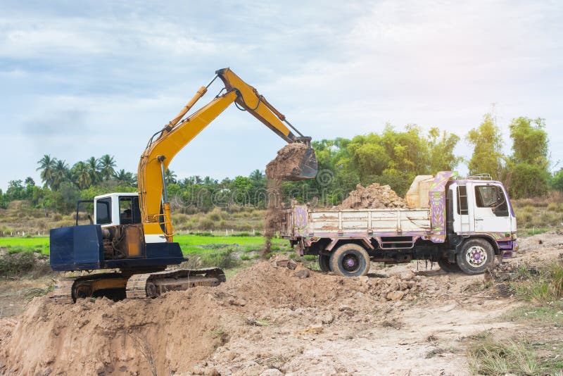 Yellow Excavator Machine Loading Soil into a Dump Truck at Construction ...