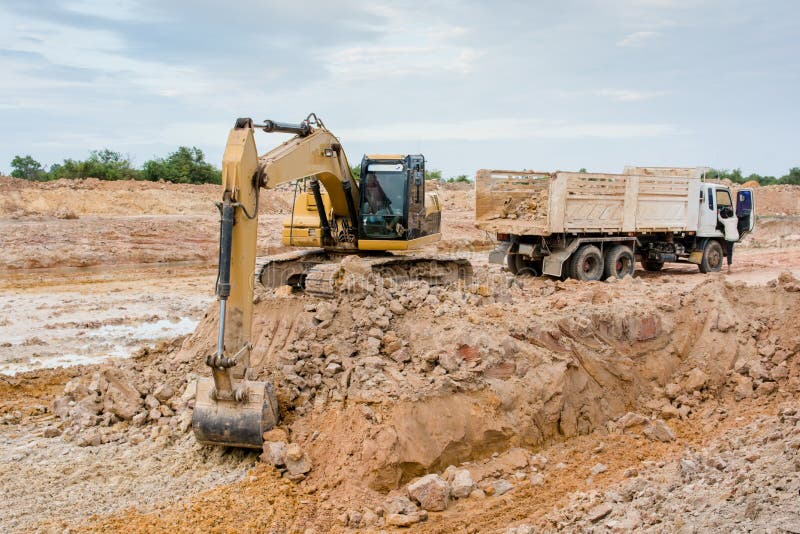 Yellow Excavator Machine Loading Soil into a Dump Truck at Construction ...