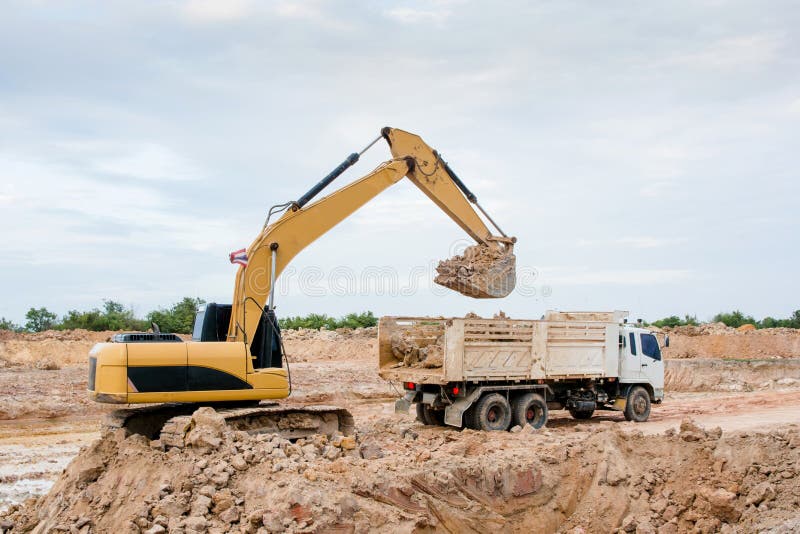 Yellow Excavator Machine Loading Soil into a Dump Truck at Construction ...