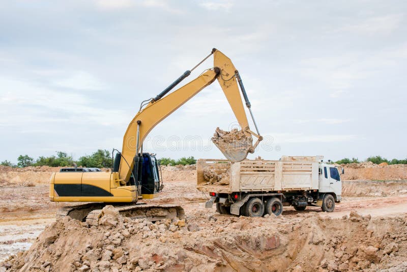 Yellow Excavator Machine Loading Soil into a Dump Truck at Construction ...