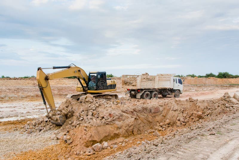 Yellow Excavator Machine Loading Soil into a Dump Truck at Construction ...
