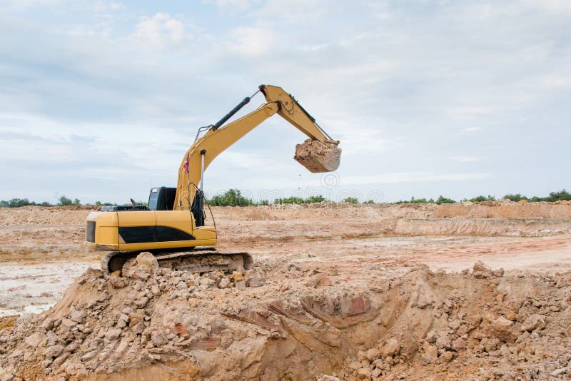 Yellow Excavator Machine Loading Soil into a Dump Truck at Construction ...