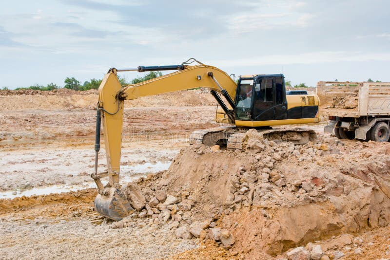 Yellow Excavator Machine Loading Soil into a Dump Truck at Construction ...
