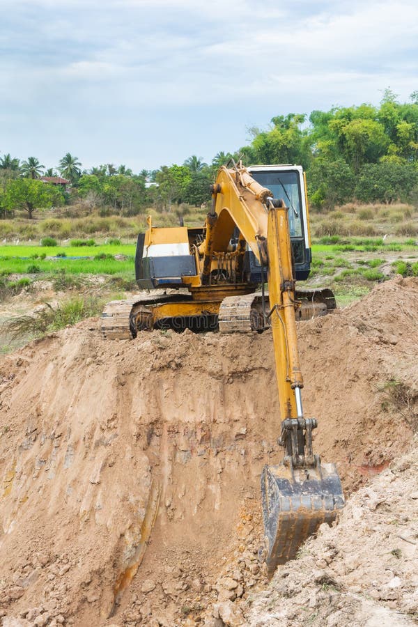 Yellow Excavator Machine Loading Soil into a Dump Truck at Construction ...