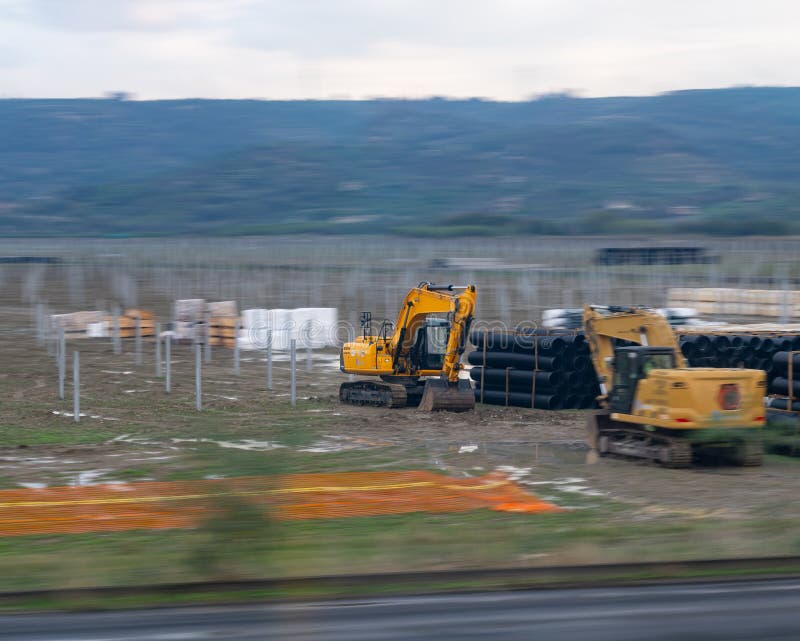 Yellow Excavator in the Middle of a Field with Panning Effects and ...