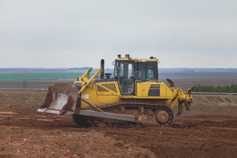 Yellow Excavator on a Road Construction Site among Fields Stock Photo ...