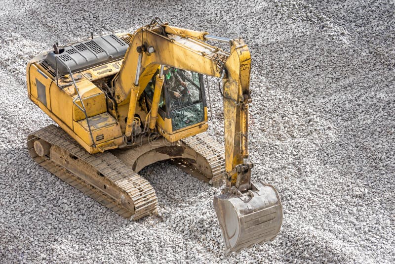 Yellow Excavator on Rubble Working Leveling Stones at Construction Site ...