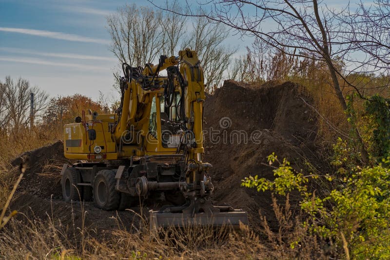 A Large Excavator, Rotary, on Wheels with a Spoon for Shaping the ...