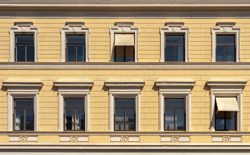 Yellow Facade of a Beautiful City Building. Windows with Cornices Stock ...