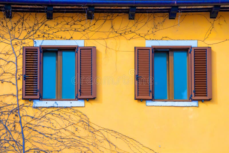 Yellow Facade of a House with Windows with Brown Shutters. Stock Photo ...
