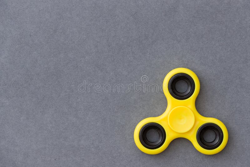 Yellow Fidget Spinner Device on Grey Background. Top View Stock Photo ...