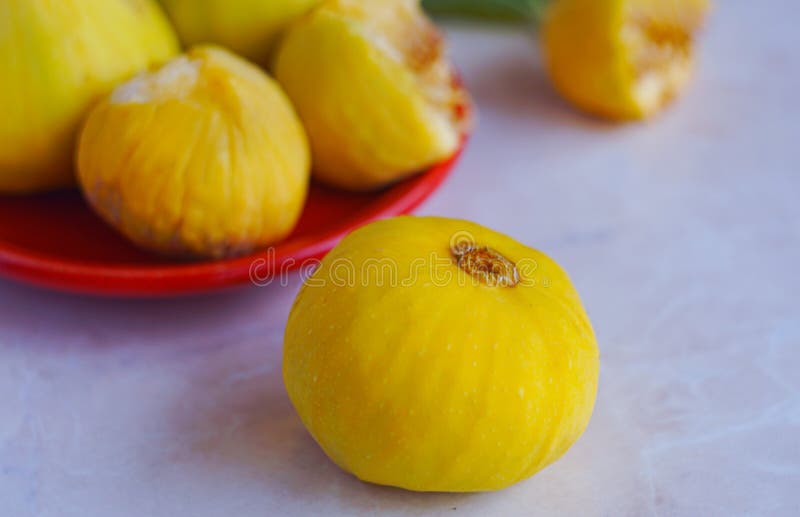 Yellow figs in a red bowl stock image. Image of food - 254687829
