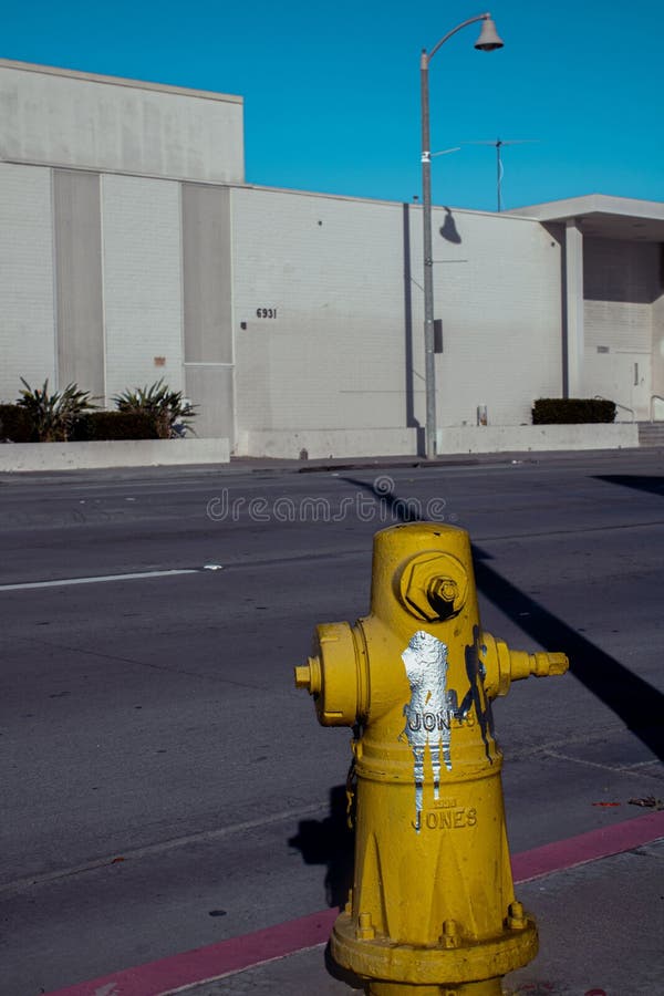 Yellow Fire Hydrant beside an Empty Road with White Buildings on the ...