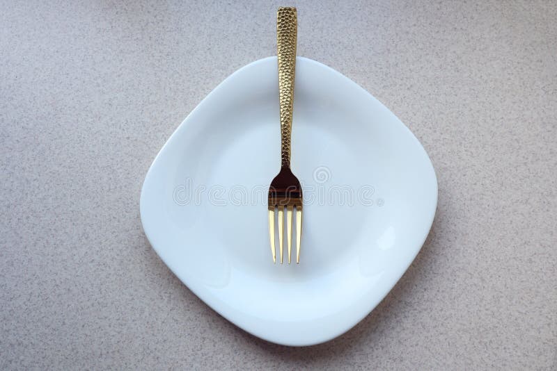 Yellow Fork on a White Plate on a Gray Background, Top View Stock Photo ...