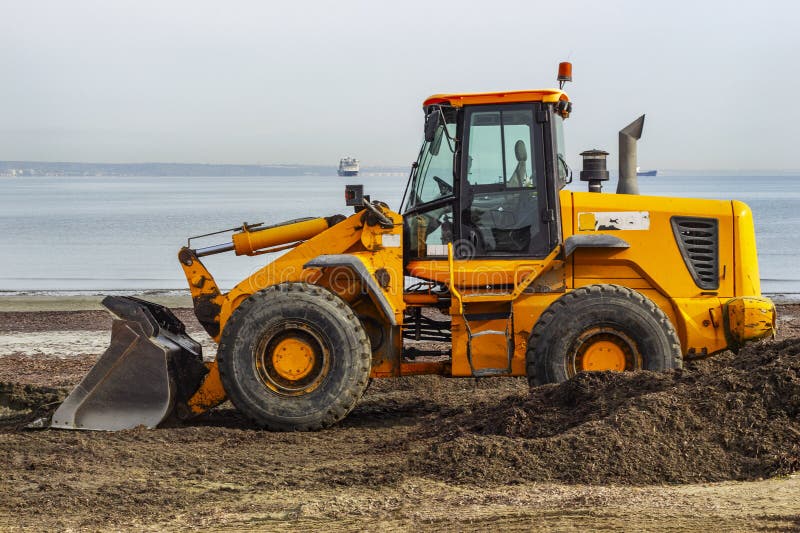 Yellow Grader Leveled the Land by the Sea. Stock Photo - Image of ...