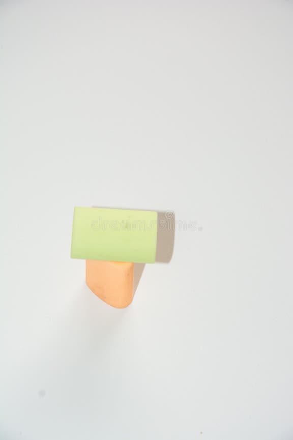 Yellow Green Eraser Stacked on Top of Orange Eraser, Placed on a Pure ...