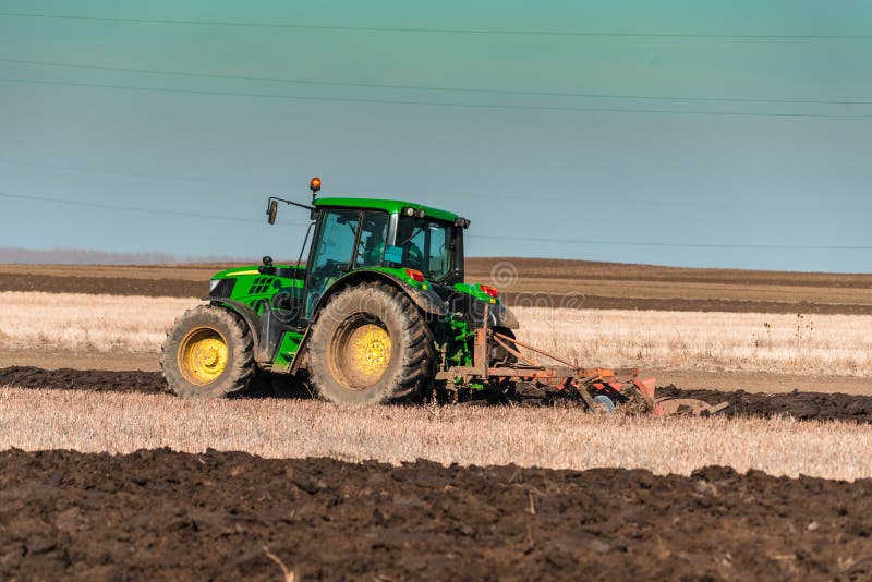 The Yellow Green Tractor Makes a Deep Plowing of the Field Editorial ...