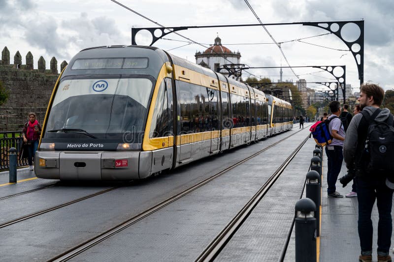 Yellow and Grey Train Chugging Down a Set of Train Tracks in a Bustling ...