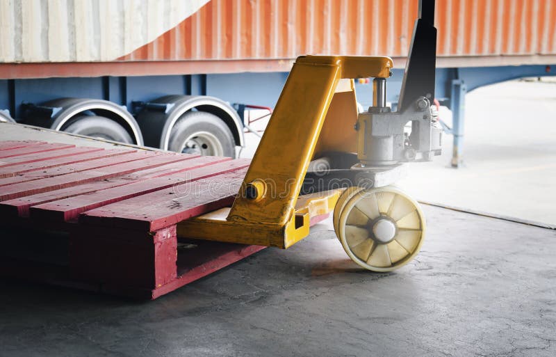 Yellow Hand Pallet Truck with Wooden Pallet Rack. Work Tools in the ...