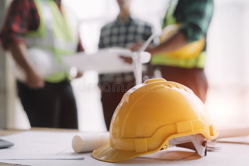 Yellow Hard Hat on Workbench with Team Discussing Data Working Start ...