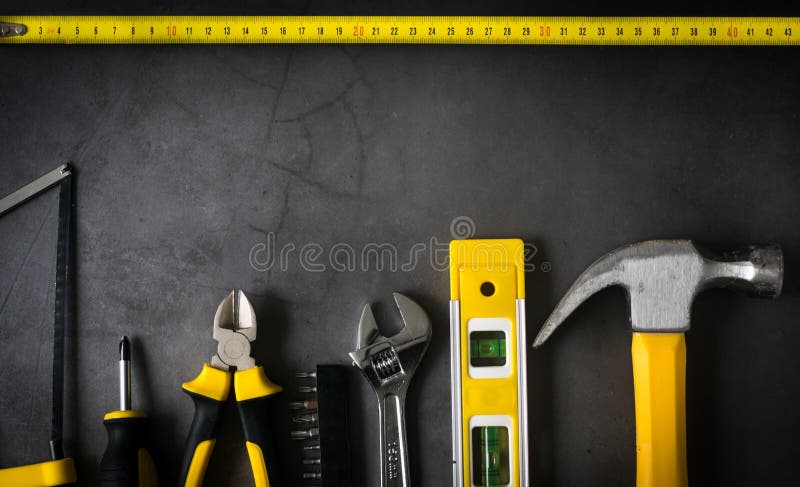 Yellow Hardware Tools on Black Concrete Background with Some Space for ...