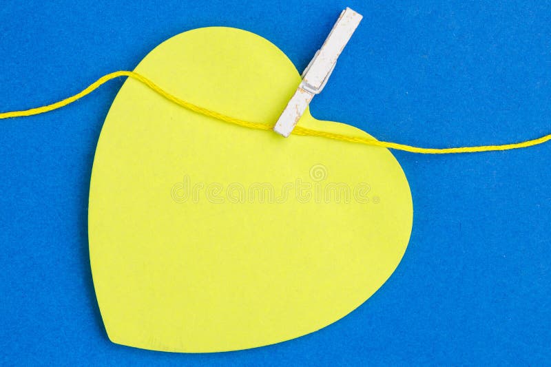 Yellow Heart-shaped Paper on Blue Background with Clothespin Hanging ...