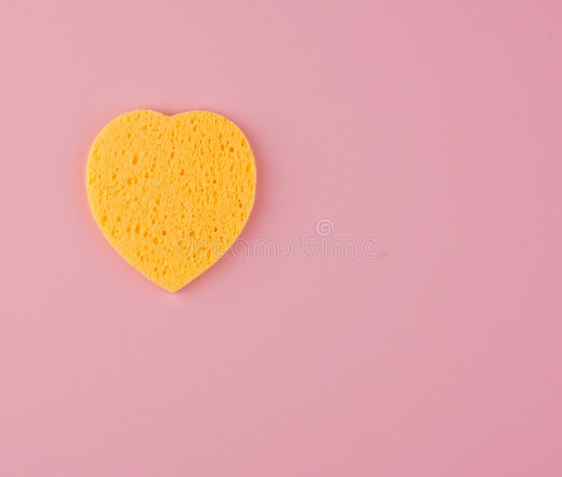 Yellow Heart Shaped Sponge for Face Wash on Pink Background Stock Photo ...
