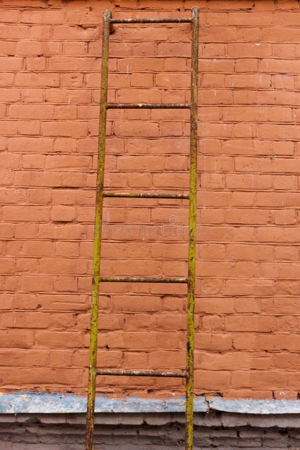 A Yellow Ladder on the Background Brick Wall. Stock Photo - Image of ...
