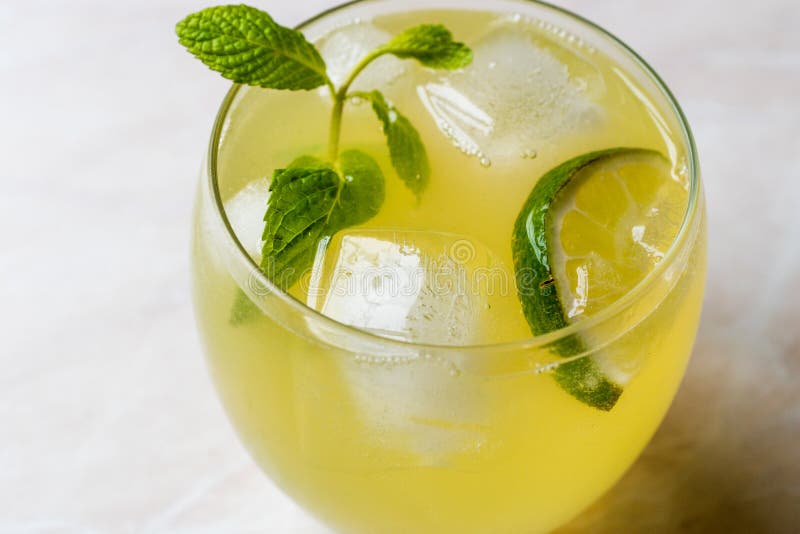 Yellow Lemonade Cocktail with Lime and Ice. Stock Photo - Image of mint ...