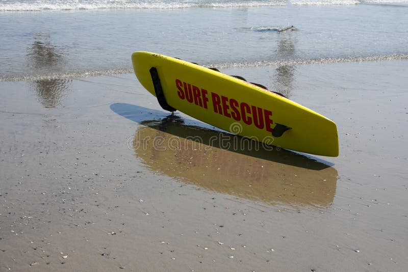 Yellow Lifeguard Surf Rescue Surf Board by the Ocean on the Sand Stock ...
