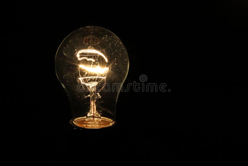 Yellow Light Bulb with Dust Particles and Black Background Stock Image ...