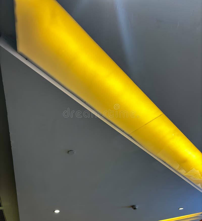 A Yellow Lighted Ceiling with a White Stripe Stock Photo - Image of ...