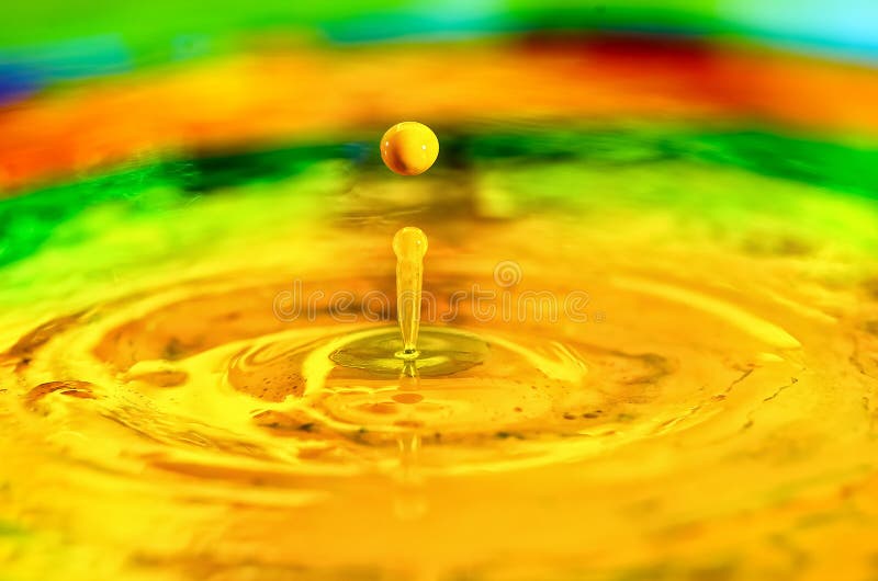 A Yellow Liquid Water Drop Splashing in Liquid Paint Stock Image ...