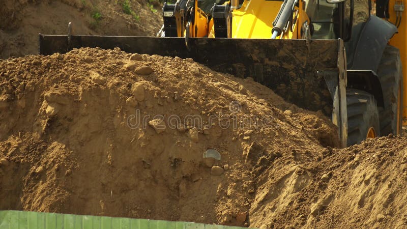 Yellow Loader Excavator Leveling the Ground at the Construction Site of ...