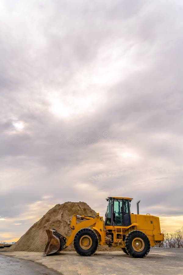 Yellow Loader Parked on a Road with a Mound of Brown Soil in the ...