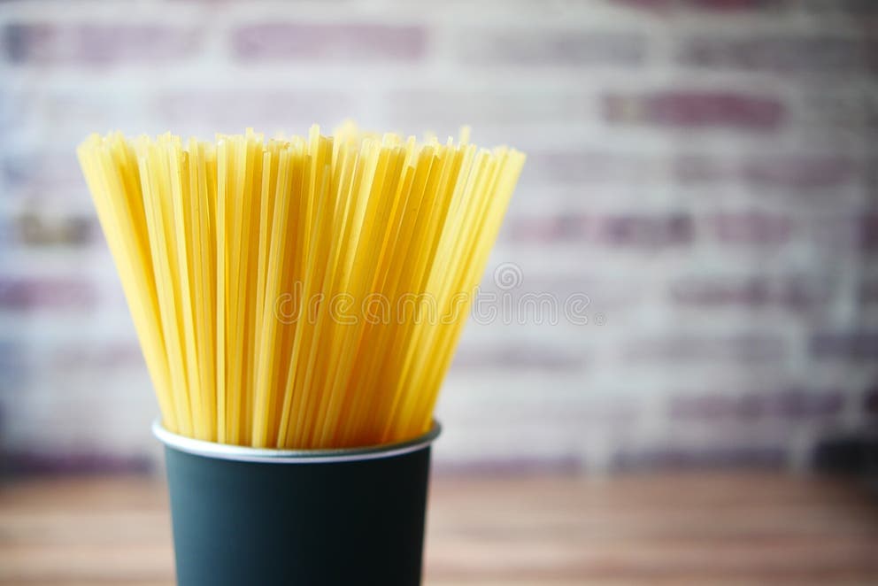 Yellow Long Spaghetti in a Container on Table Stock Photo - Image of ...
