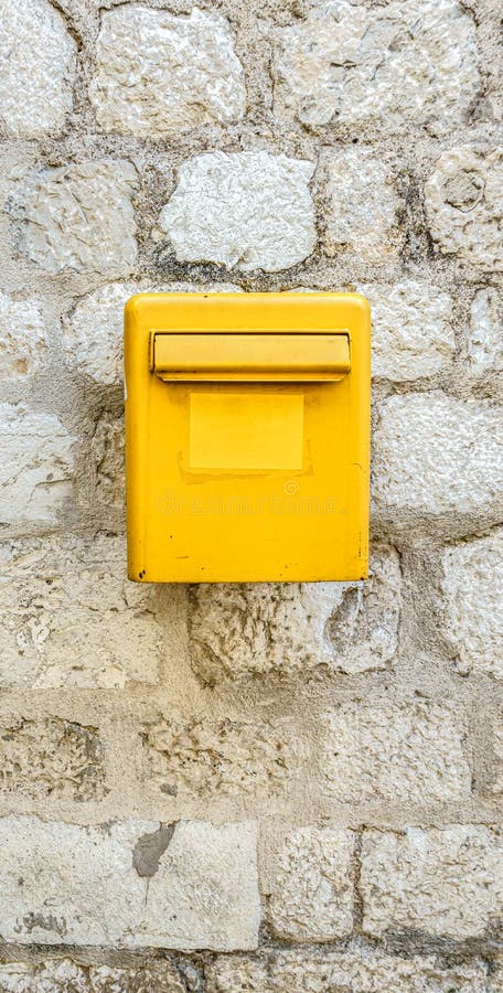 A Yellow Mailbox on a Light Stone Wall. Box for Letters and Postcards ...