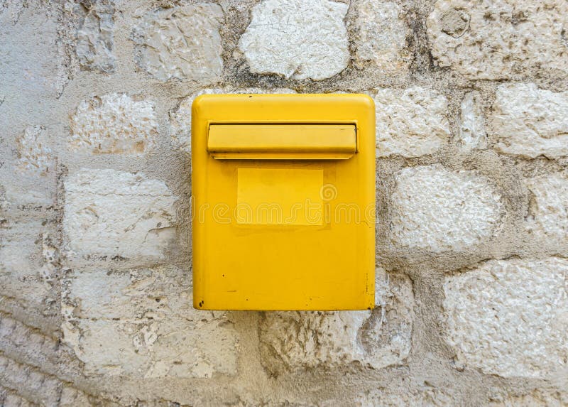 A Yellow Mailbox on a Light Stone Wall. Box for Letters and Postcards ...